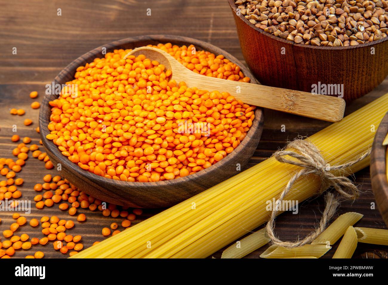 front view raw pasta with buckwheat and lentils on brown background ...
