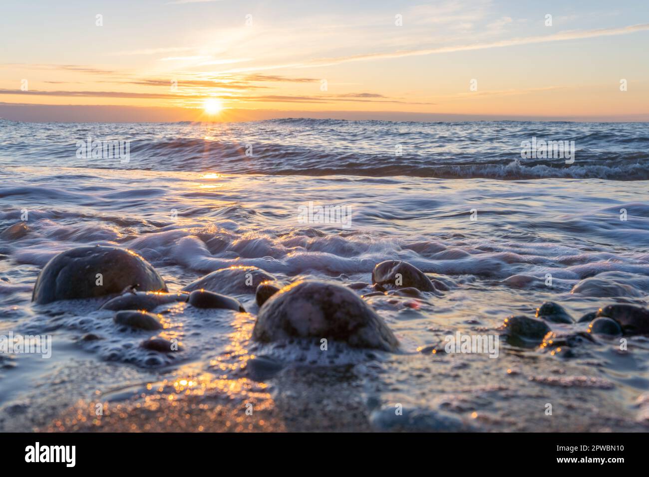 dreamlike, orange, sunset between rocks in the sea of the Baltic Sea ...