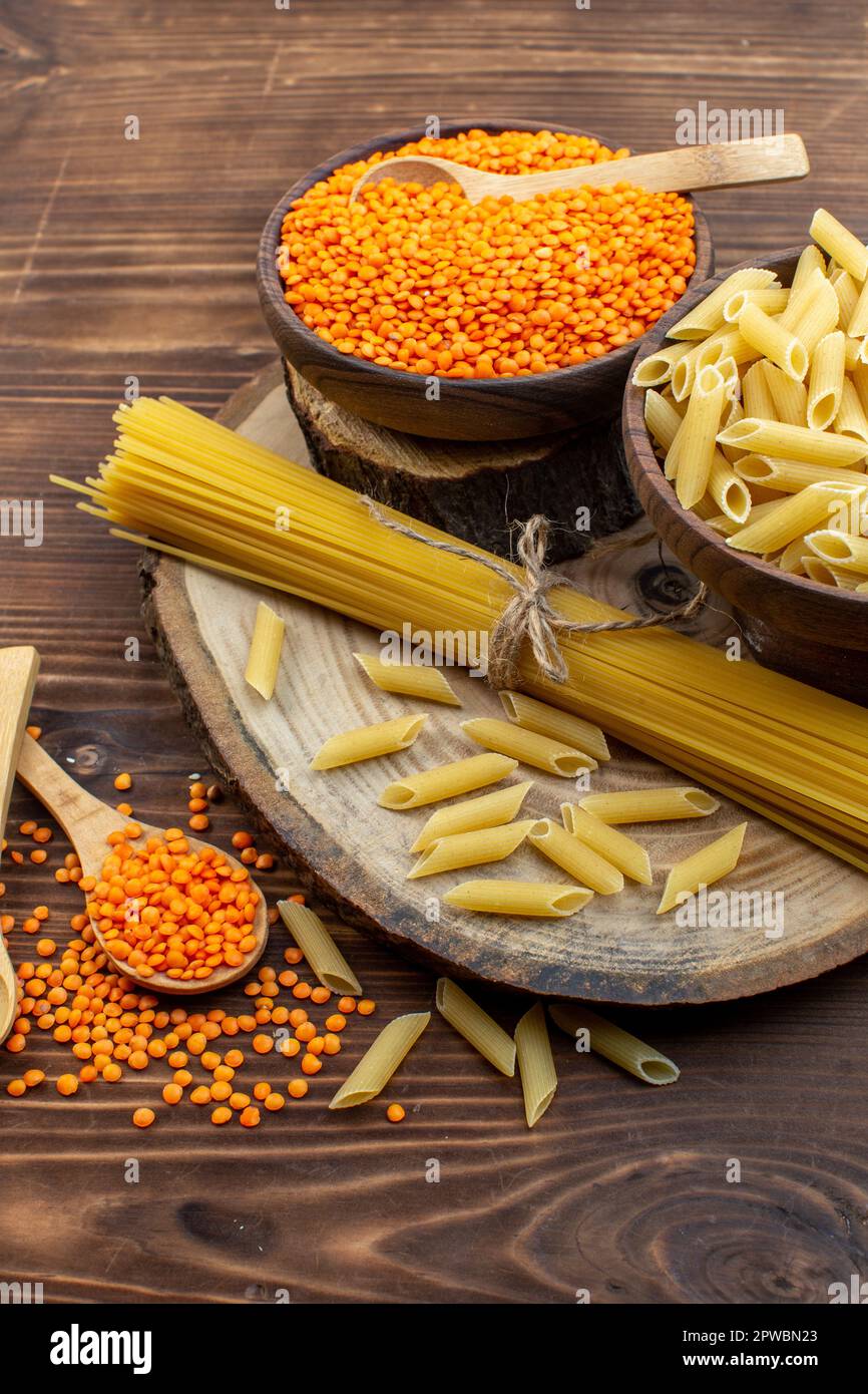 front view raw pasta with orange lentils on brown background spaghetti ...