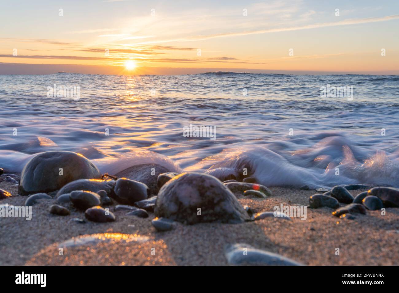 dreamlike, orange, sunset between rocks in the sea of the Baltic Sea ...