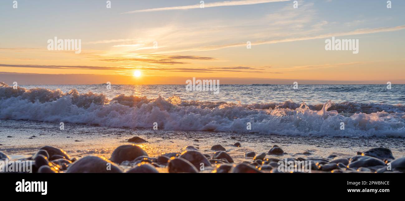 dreamlike, orange, sunset between rocks in the sea of the Baltic Sea ...