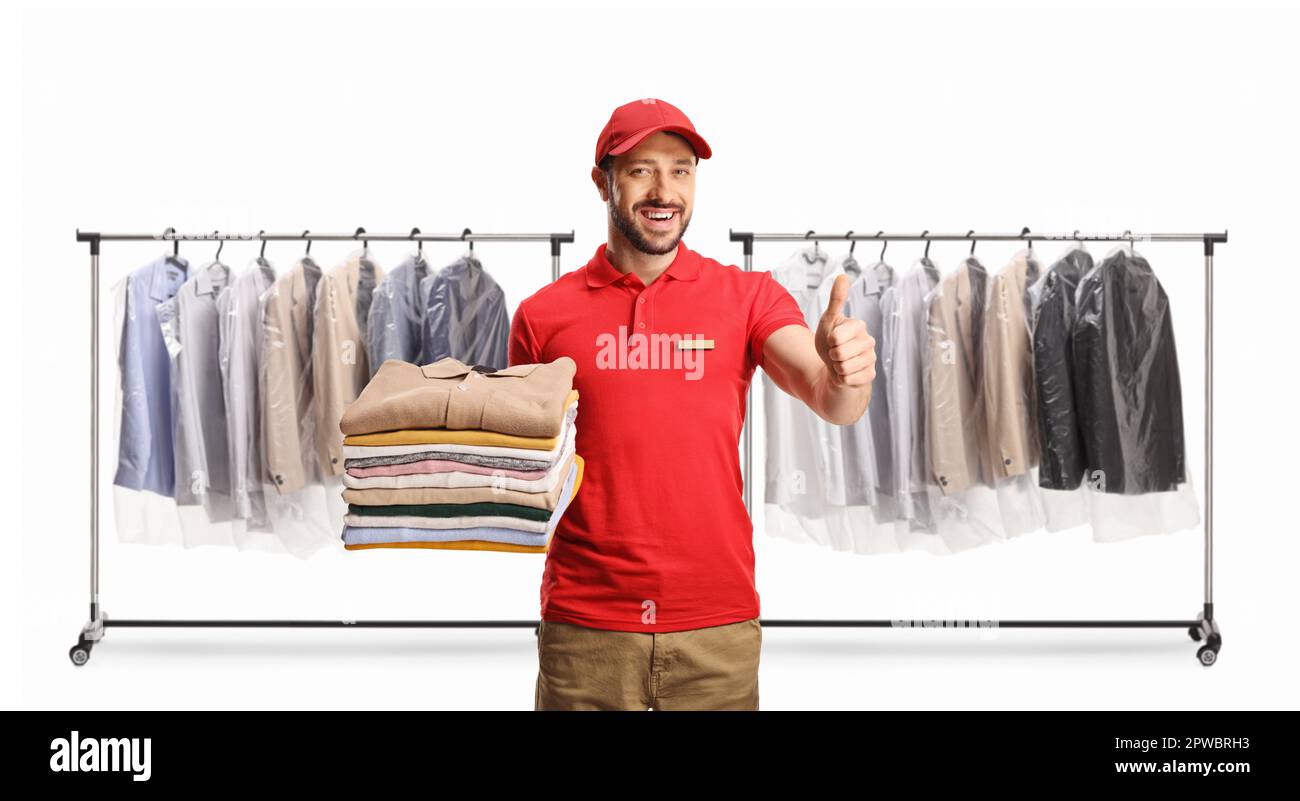 Laundry worker holding a pile of folded clothes and gesturing thumbs up ...