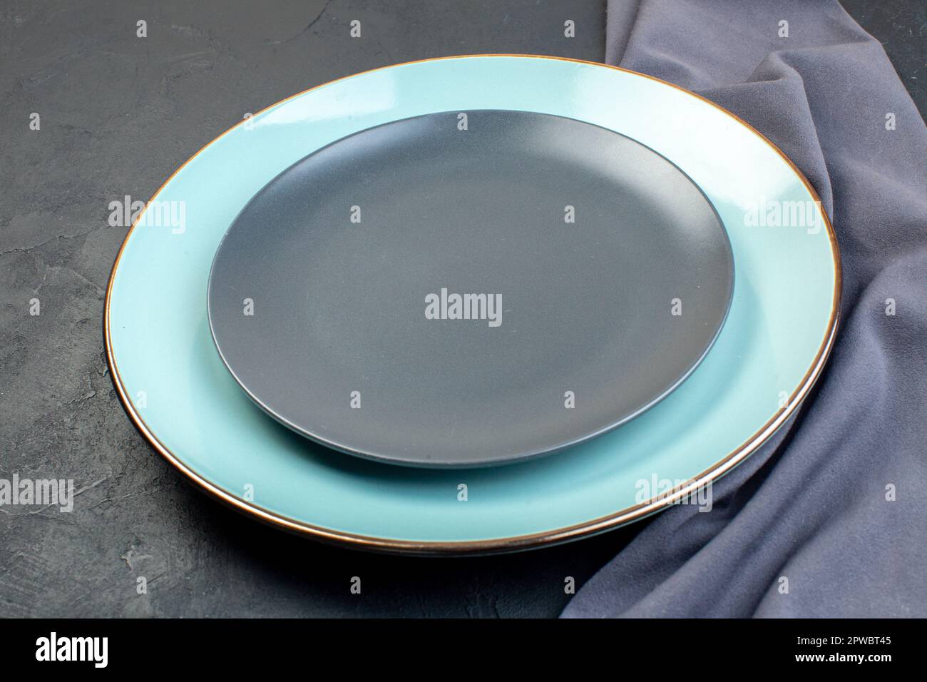 front view blue plate with gray plate on dark background silverware ...