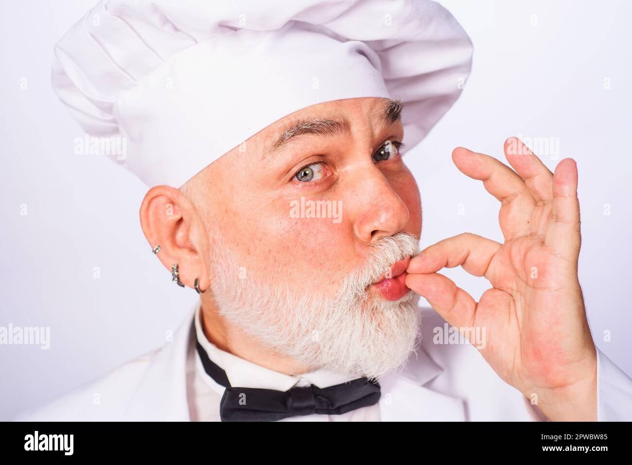 Male chef in white uniform and bow tie with perfect sign. Cook with ...
