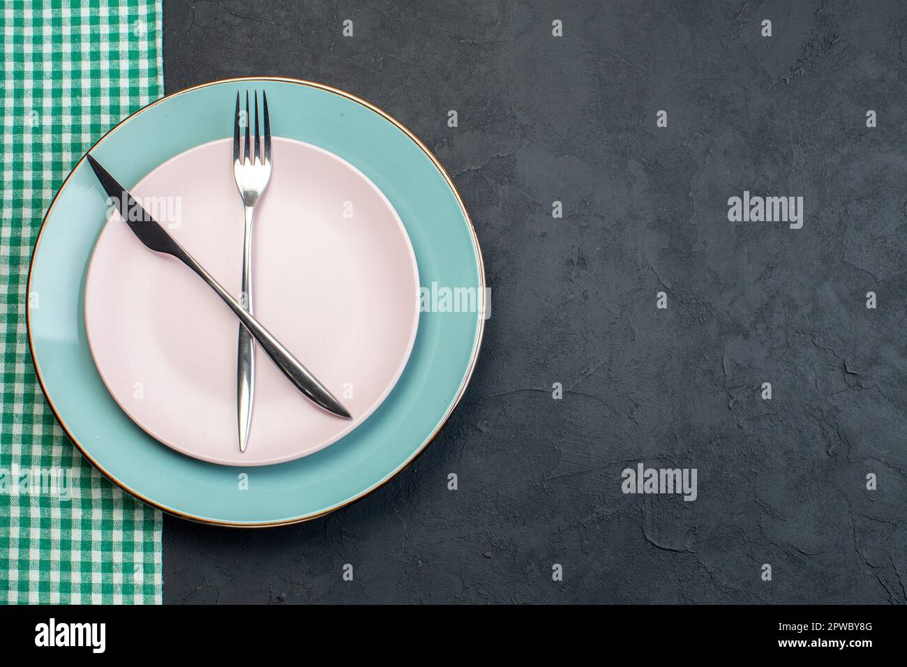 top view elegant pink plate with blue plate fork and knife dark ...