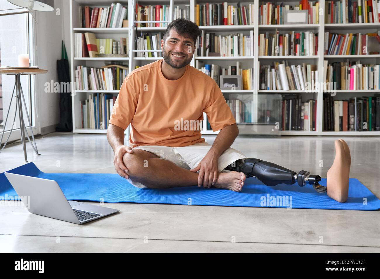 Amputee man with prosthetic leg prosthesis doing exercises at home with ...