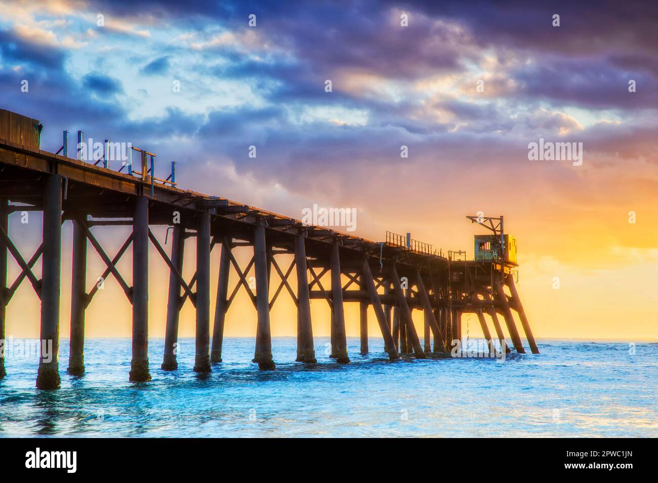Sunlit historic timber jetty at Catherine Hill bay MIddle camp beach on ...