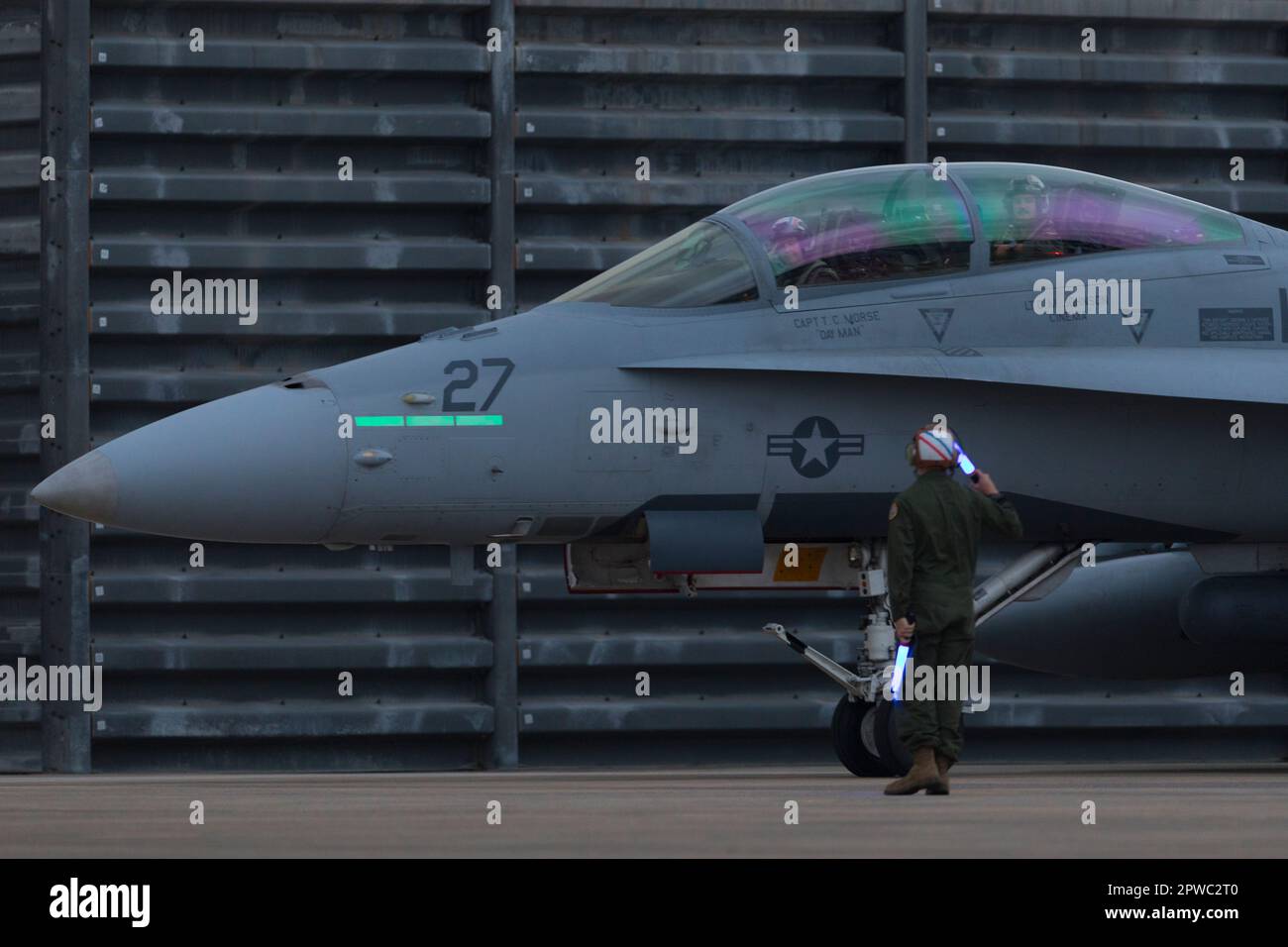 A U.S. Marine salutes the aircrew of an F/A-18D Hornet aircraft with ...