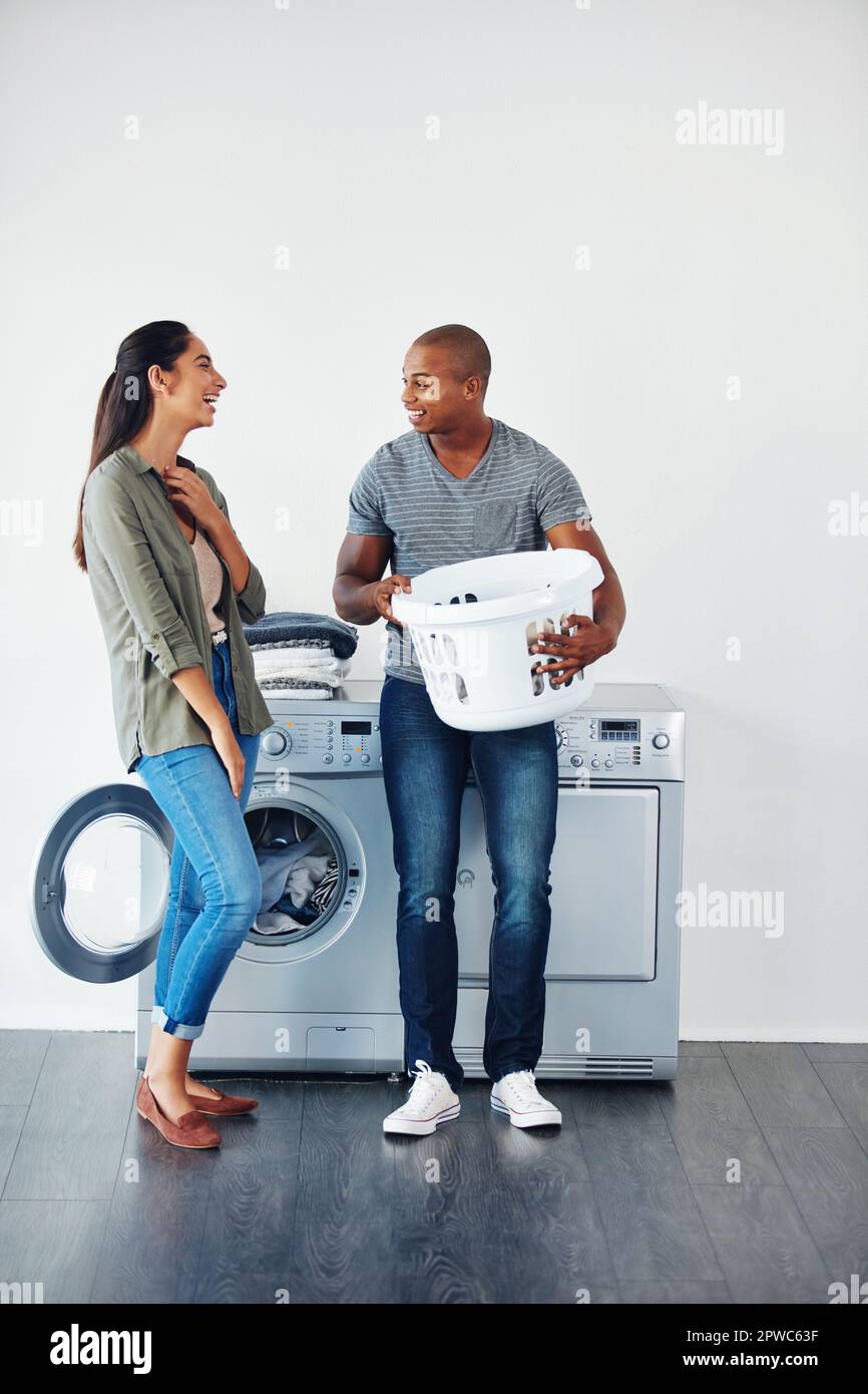 He gladly offers to help with chores. a young woman doing laundry at ...