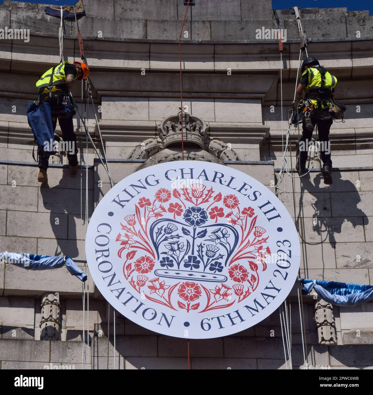 Workers install a huge coronation emblem on the Admiralty Arch in The ...