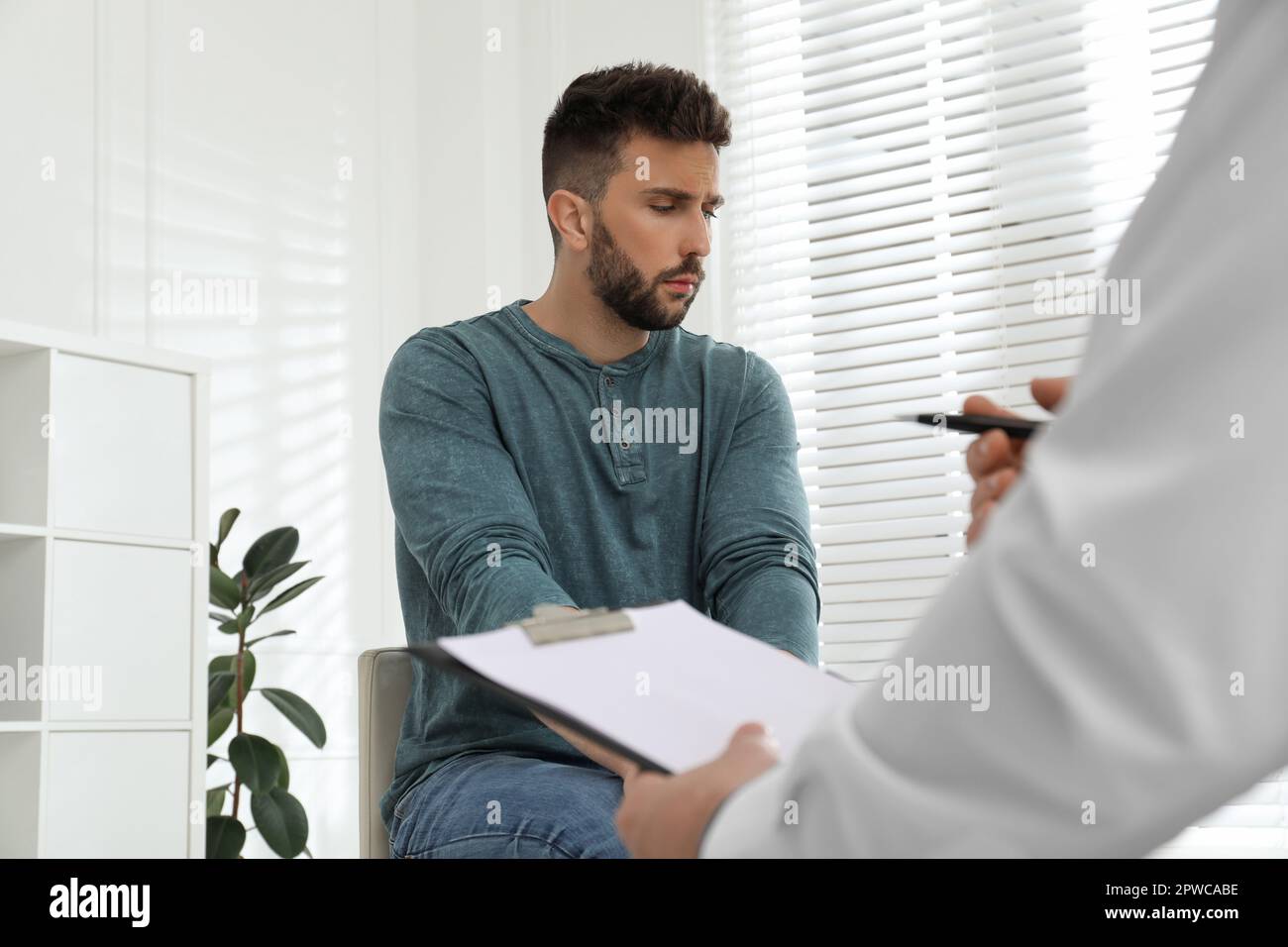 Psychotherapist working with drug addicted man indoors Stock Photo - Alamy