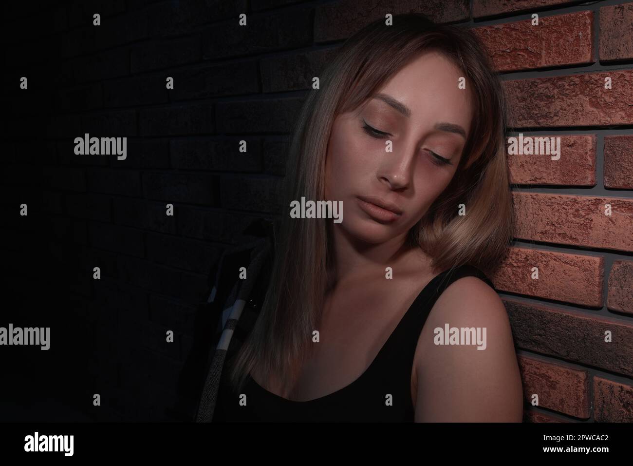 Overdosed drug addicted woman near brick wall Stock Photo - Alamy