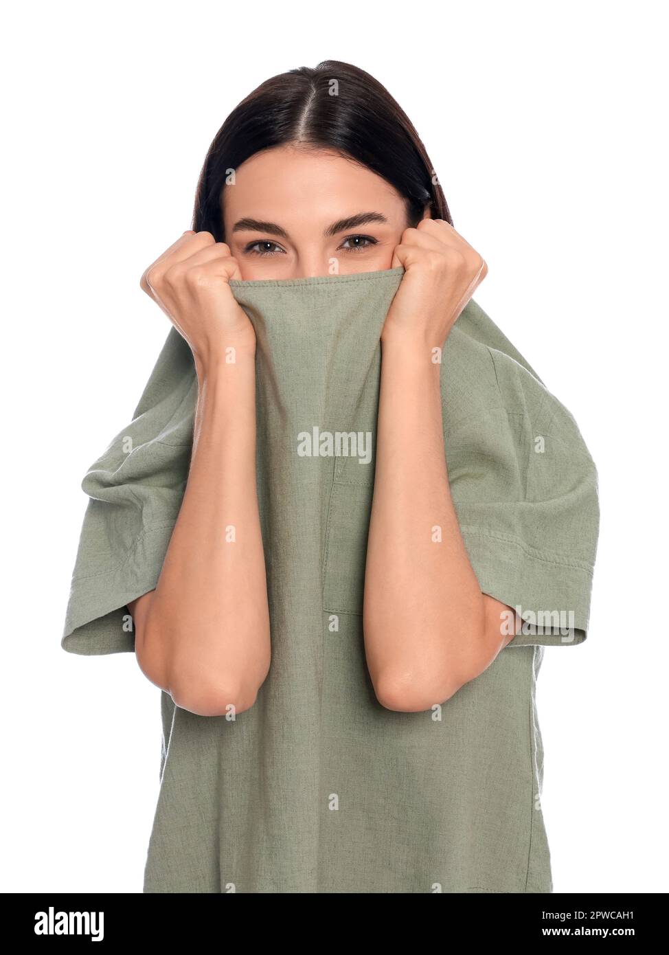 Embarrassed young woman covering face with shirt on white background ...