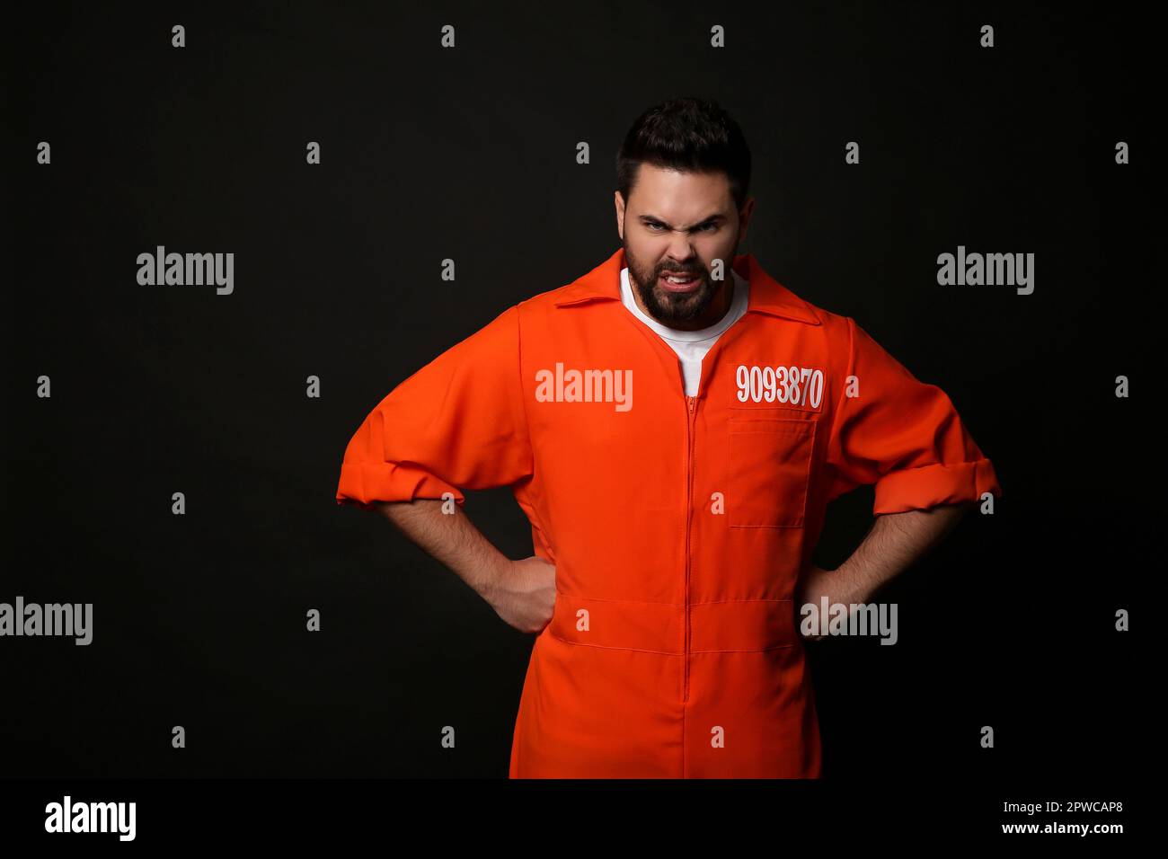 Angry prisoner in jumpsuit on black background Stock Photo - Alamy