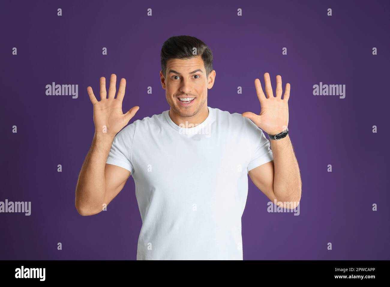 Man showing number ten with his hands on purple background Stock Photo ...