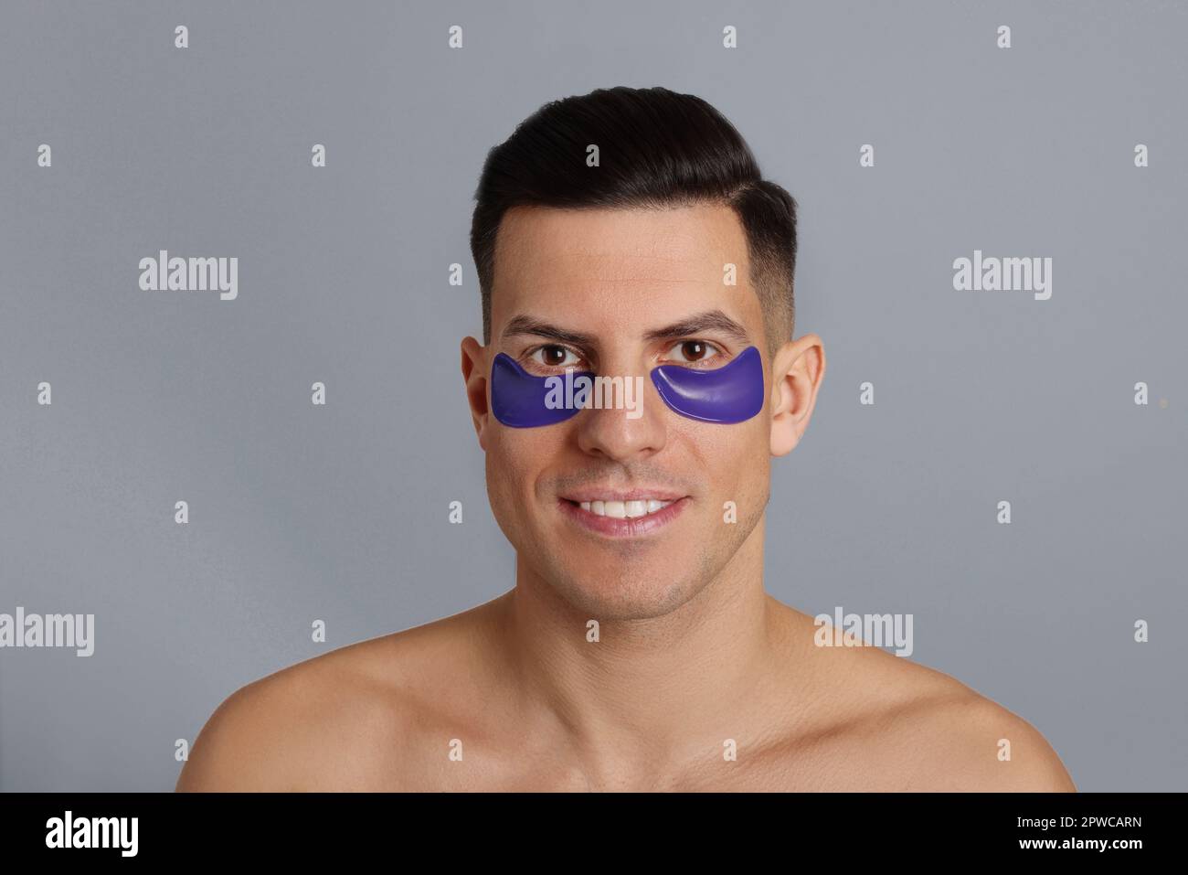 Man with blue under eye patches on grey background Stock Photo - Alamy