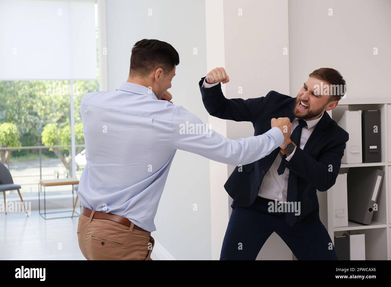 Emotional colleagues fighting in office. Workplace conflict Stock Photo ...