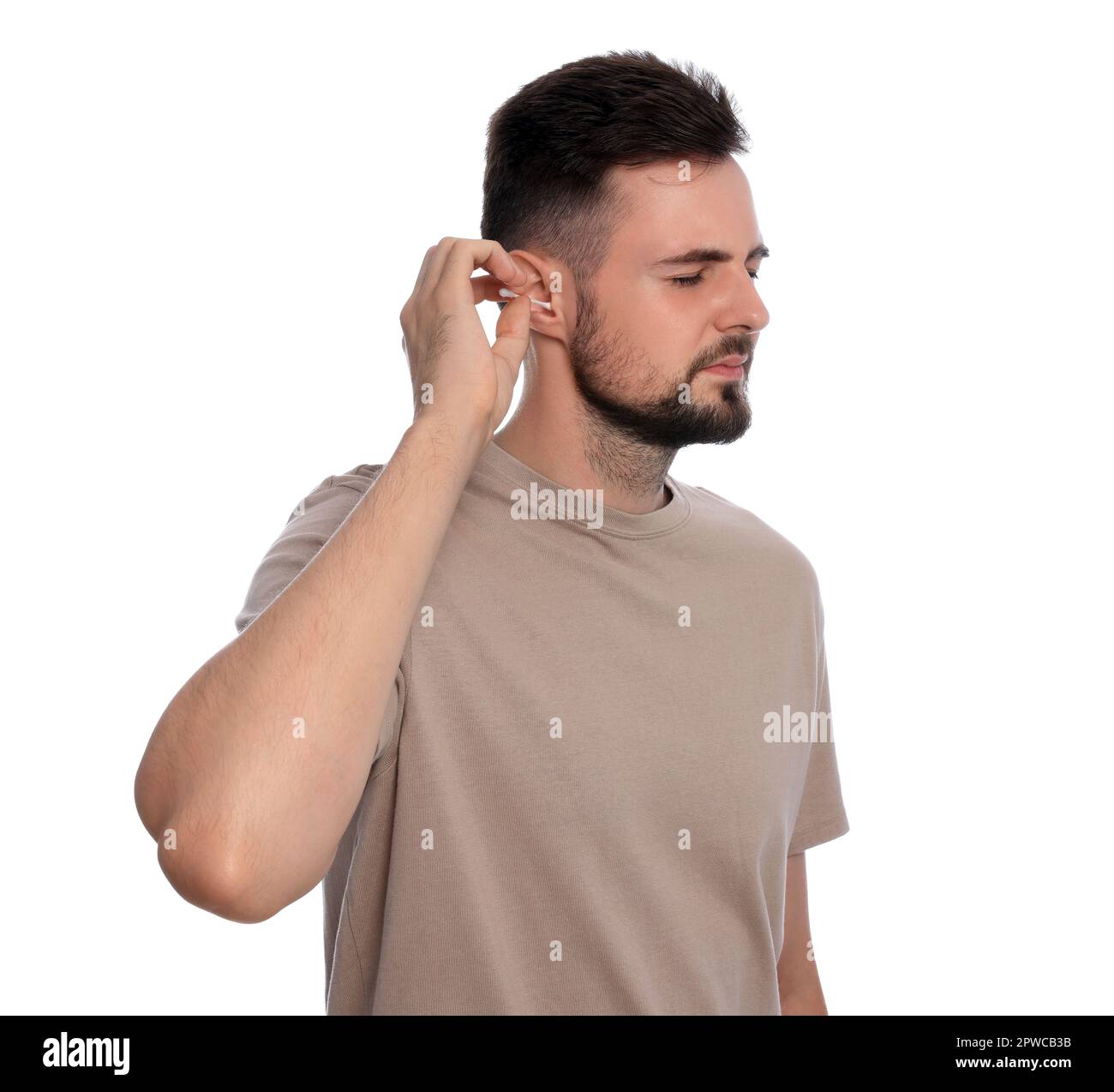 Young man cleaning ear with cotton swab on white background Stock Photo ...