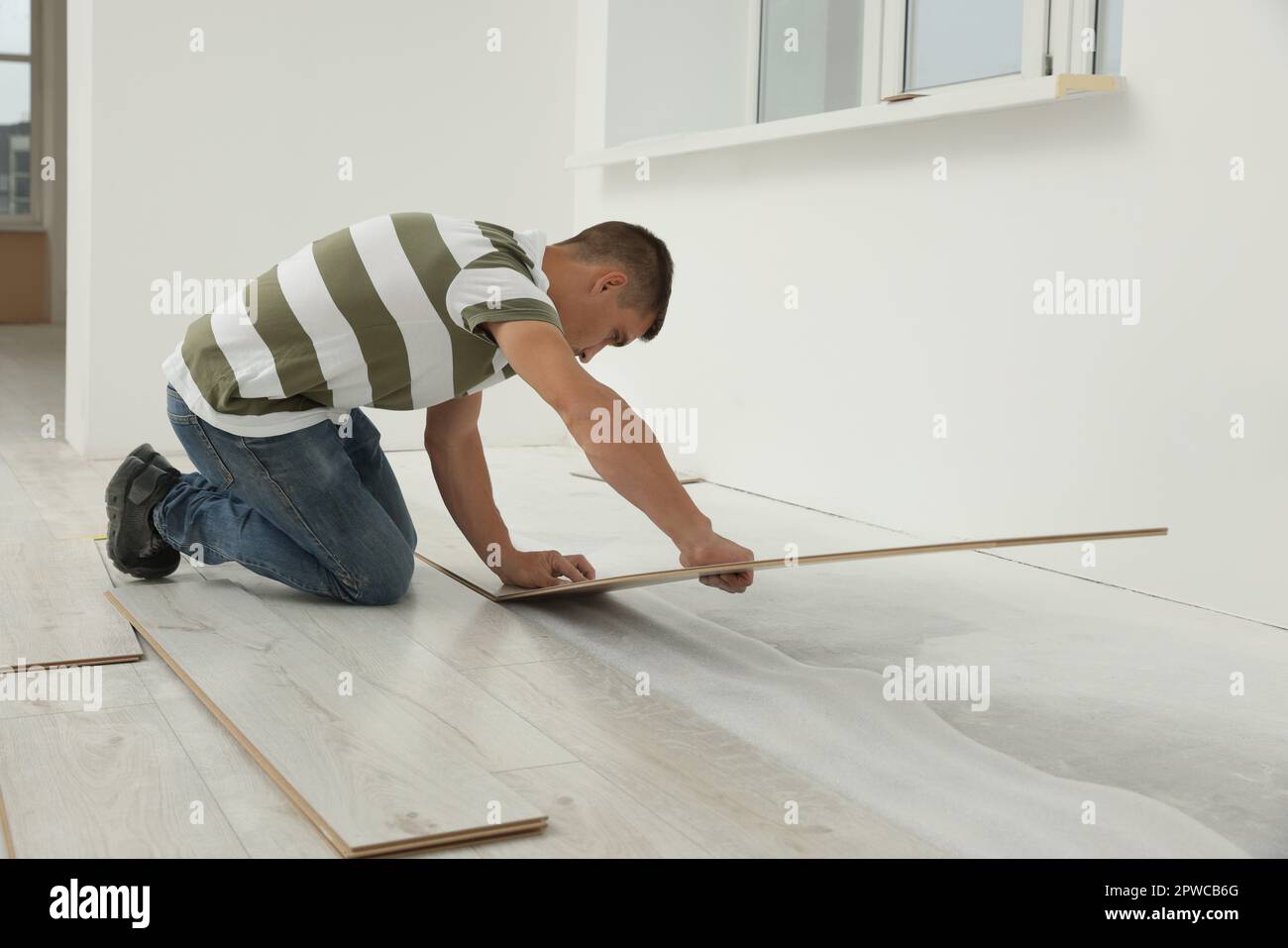 Professional worker installing new laminate flooring indoors Stock ...