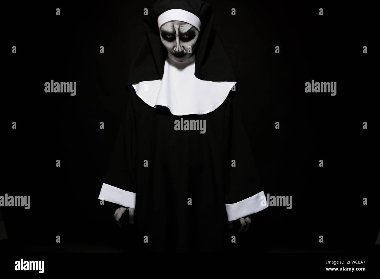 Portrait of scary devilish nun on black background. Halloween party ...