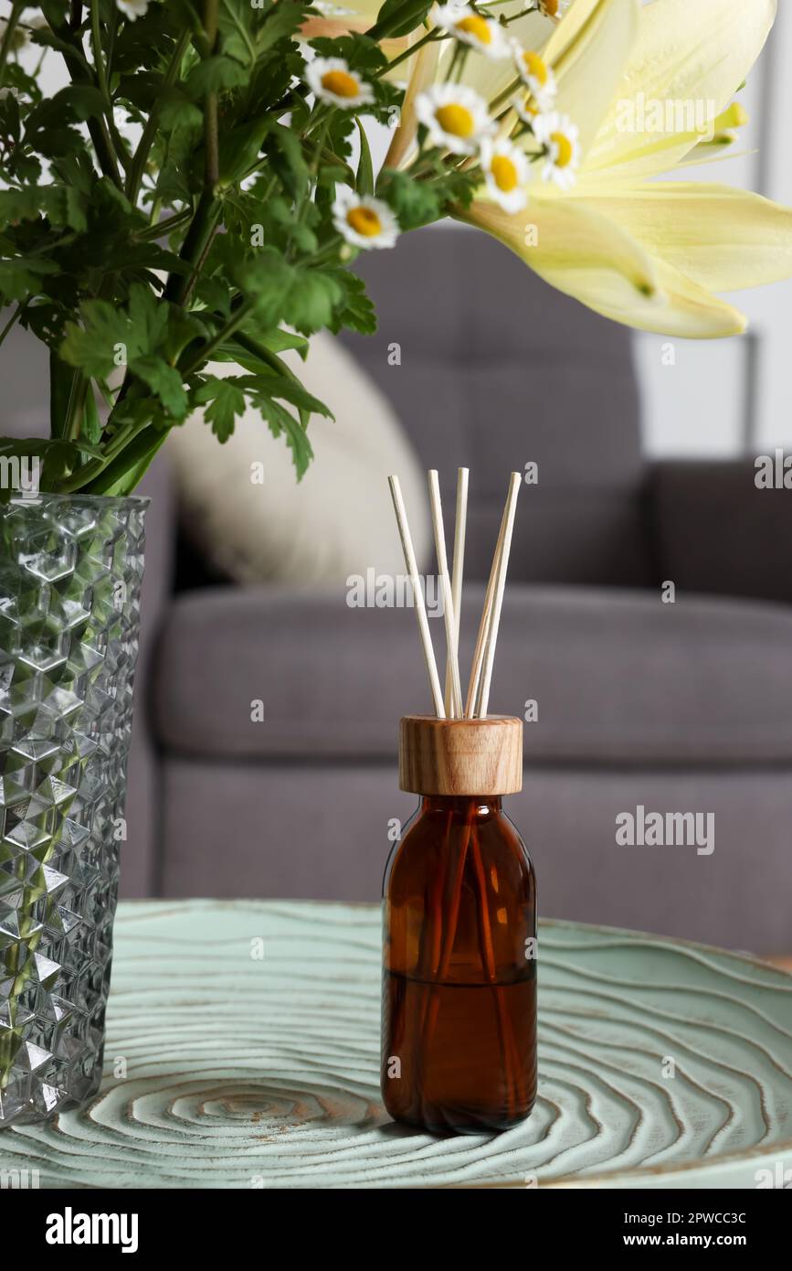 Aromatic reed air freshener near flowers on texture table Stock Photo ...