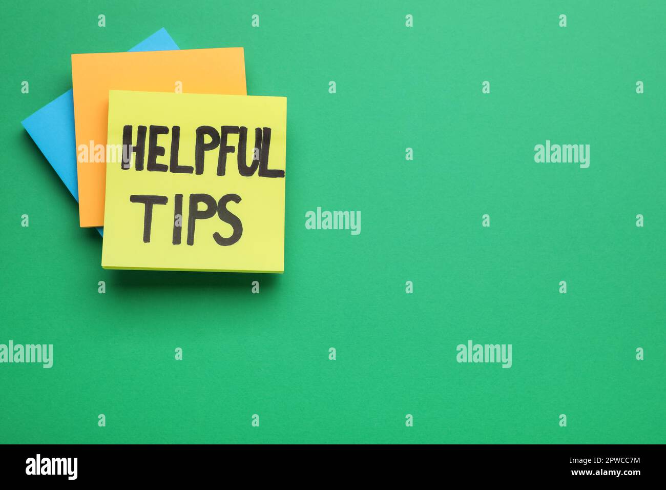 Paper note with phrase Helpful Tips on green background, top view ...