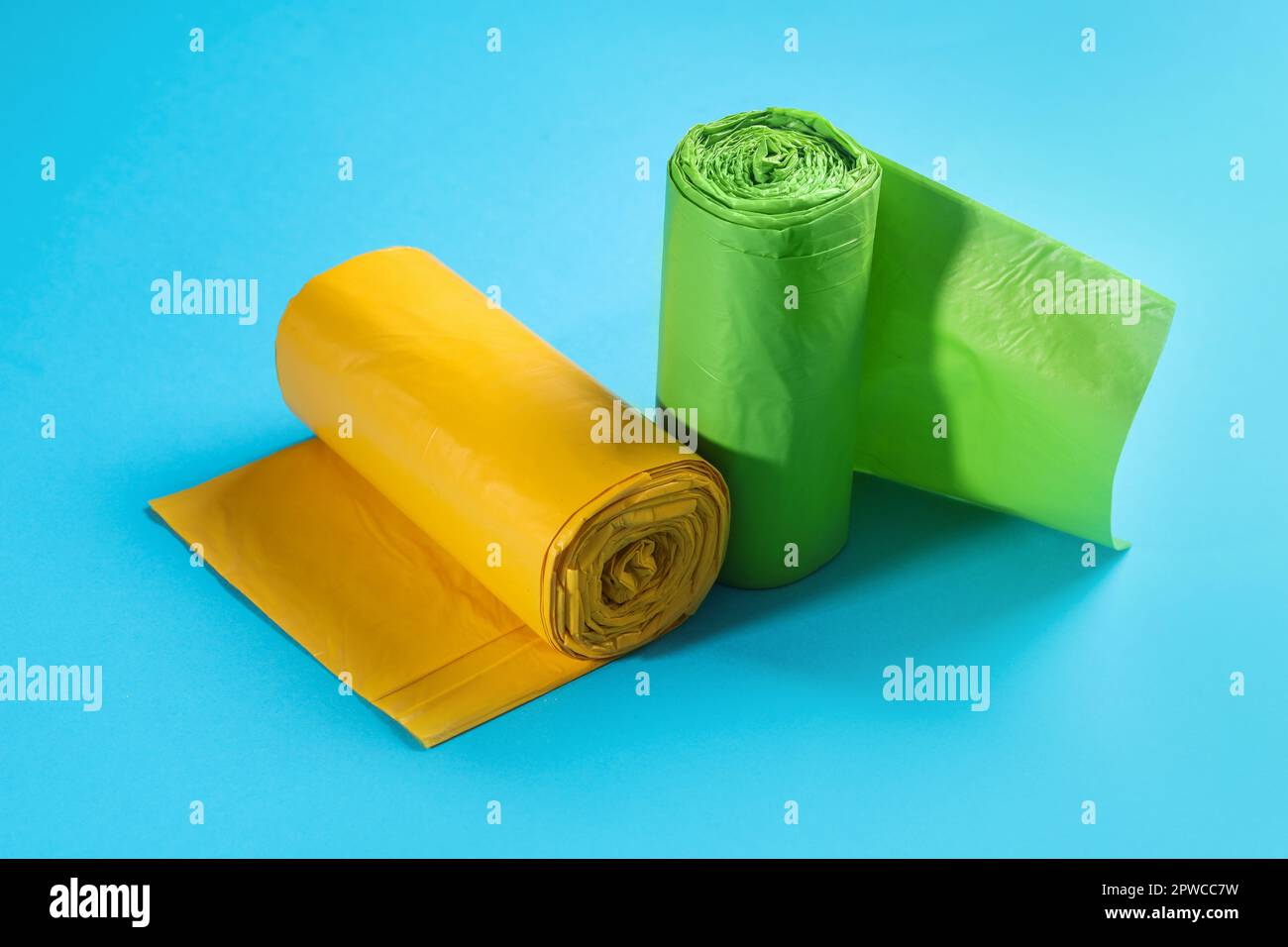 Rolls of garbage bags on light blue background Stock Photo - Alamy