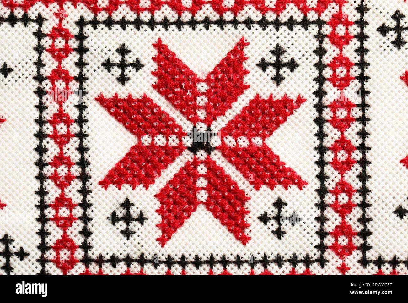 Traditional Ukrainian embroidery on white canvas as background, closeup ...