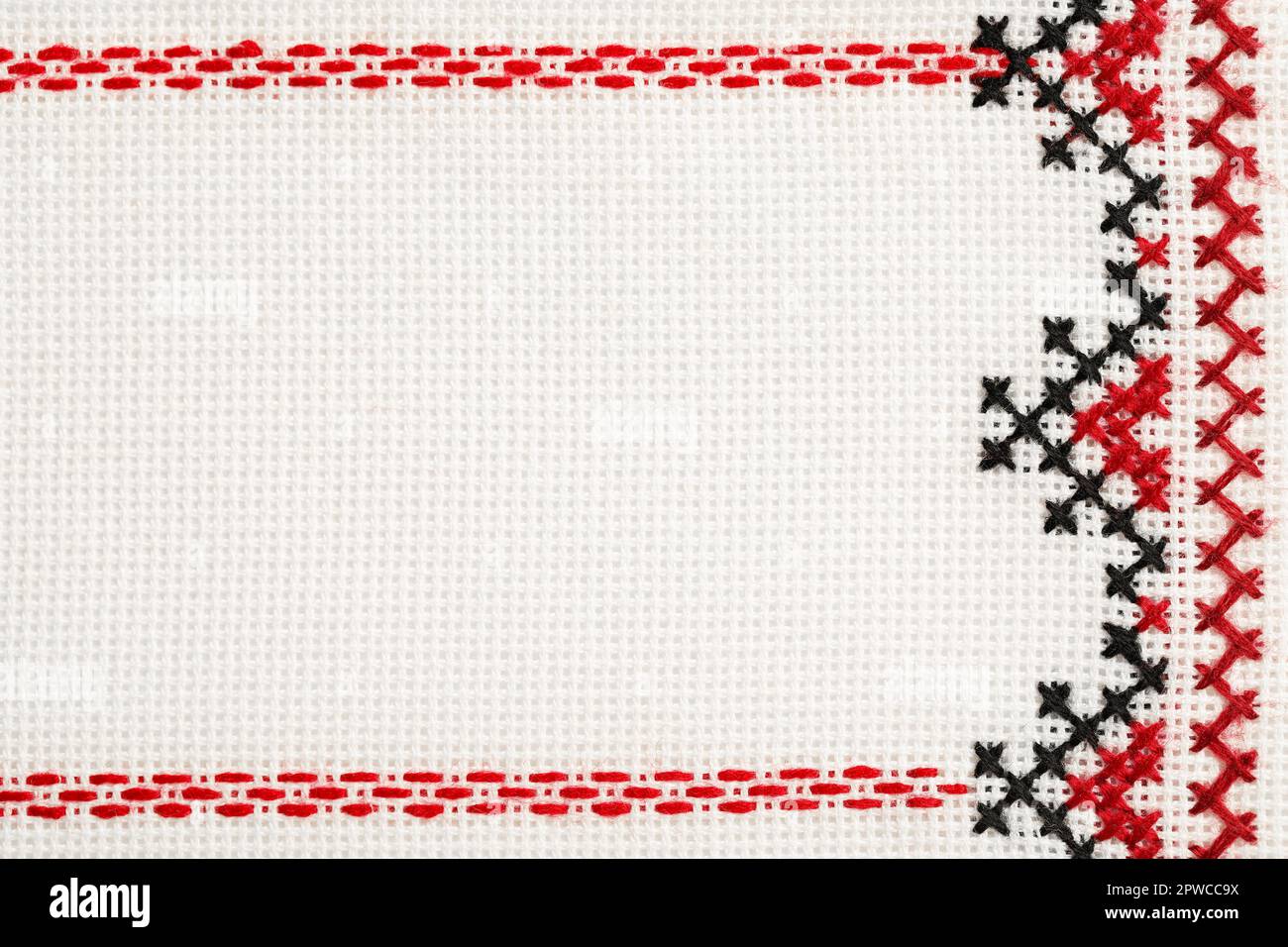 Traditional Ukrainian embroidery on white canvas as background, closeup ...