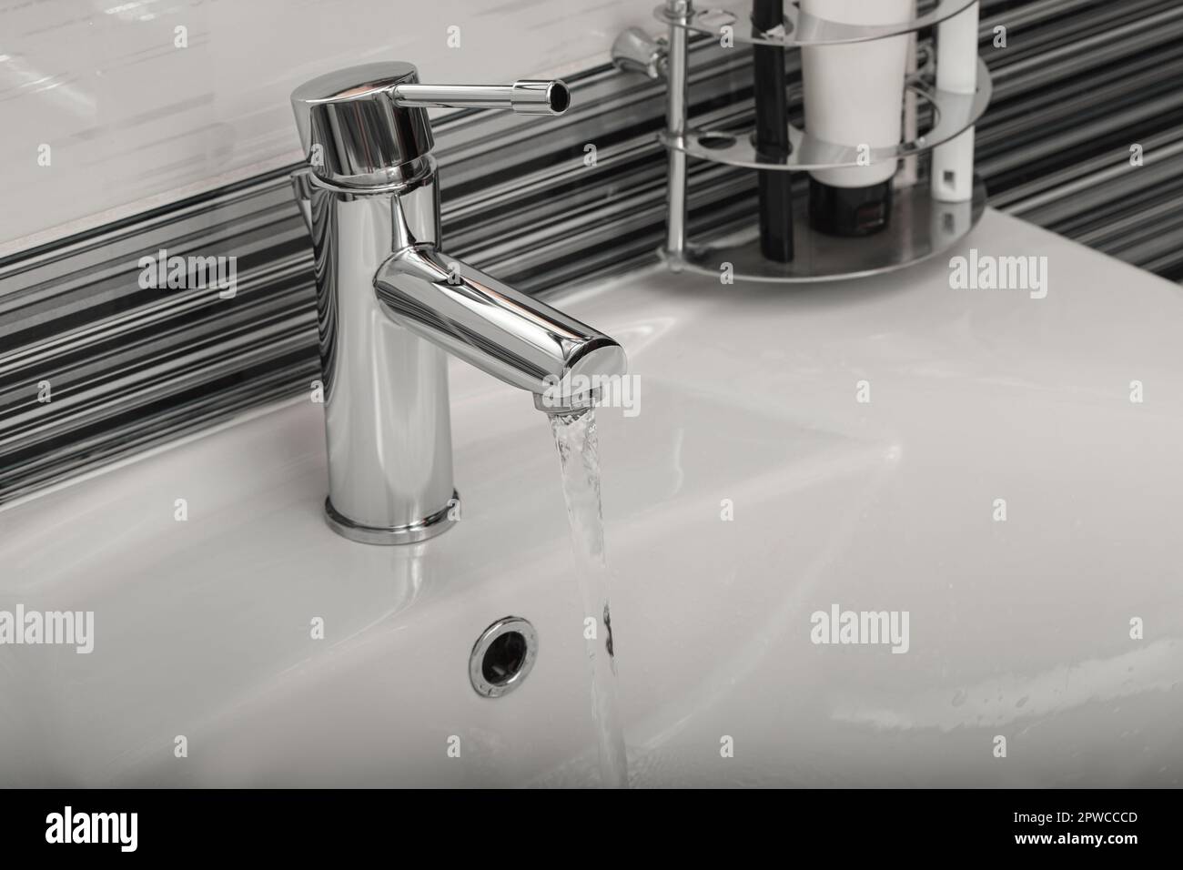 Stream of water flowing from tap in bathroom Stock Photo - Alamy