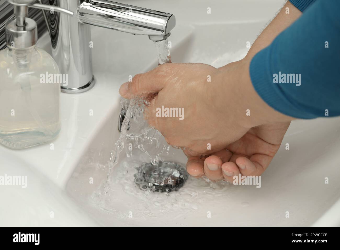 Man using water tap to wash hands in bathroom, closeup Stock Photo - Alamy