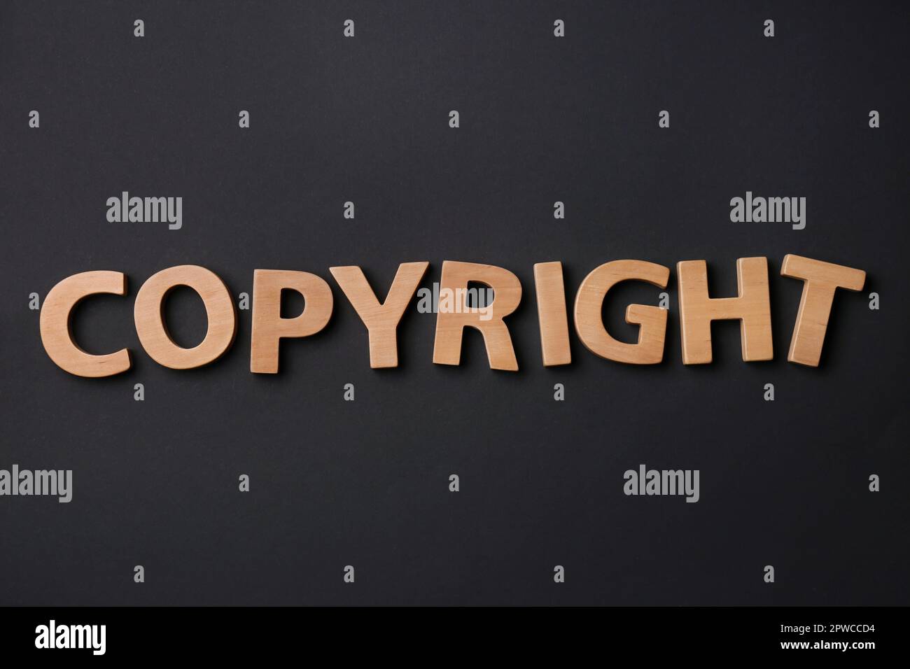 Word Copyright made of wooden letters on black background, flat lay ...