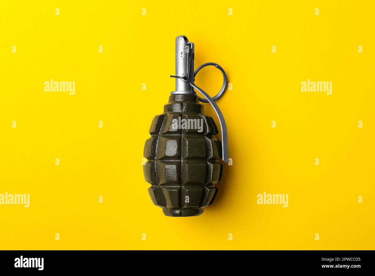 Hand grenade on yellow background, top view Stock Photo - Alamy