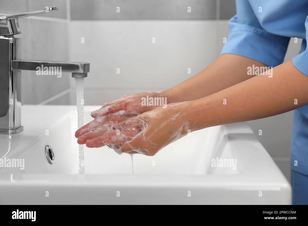 Doctor washing hands with water from tap in bathroom, closeup Stock ...
