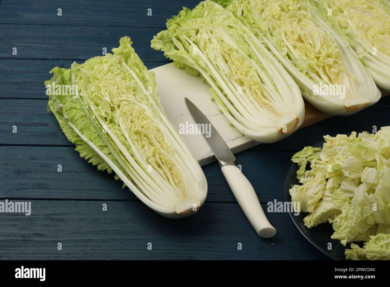 Cut fresh ripe Chinese cabbages on blue wooden table Stock Photo - Alamy