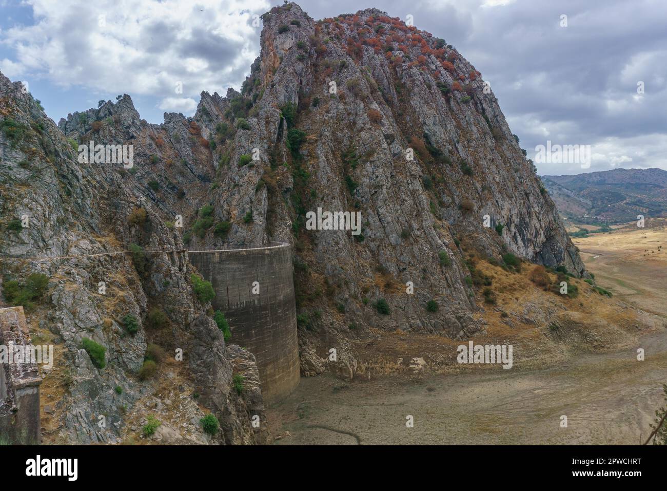 An empty, dry reservoir or dam with land cracked by drought and climate ...