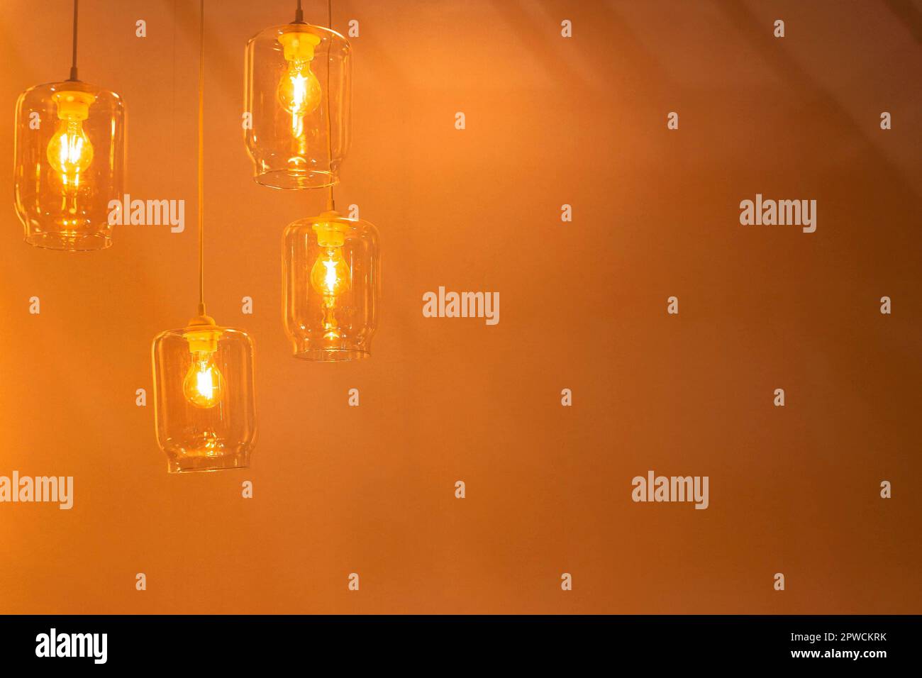 Low angle set of creative transparent glass lamps with glowing bulbs ...