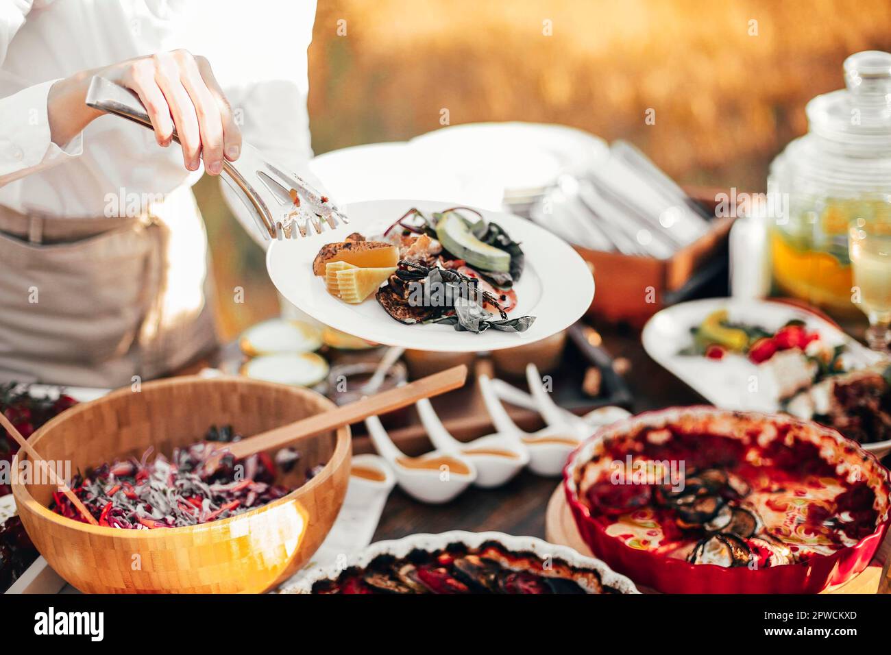 High angle of crop anonymous person with tongs taking piece of cheese ...