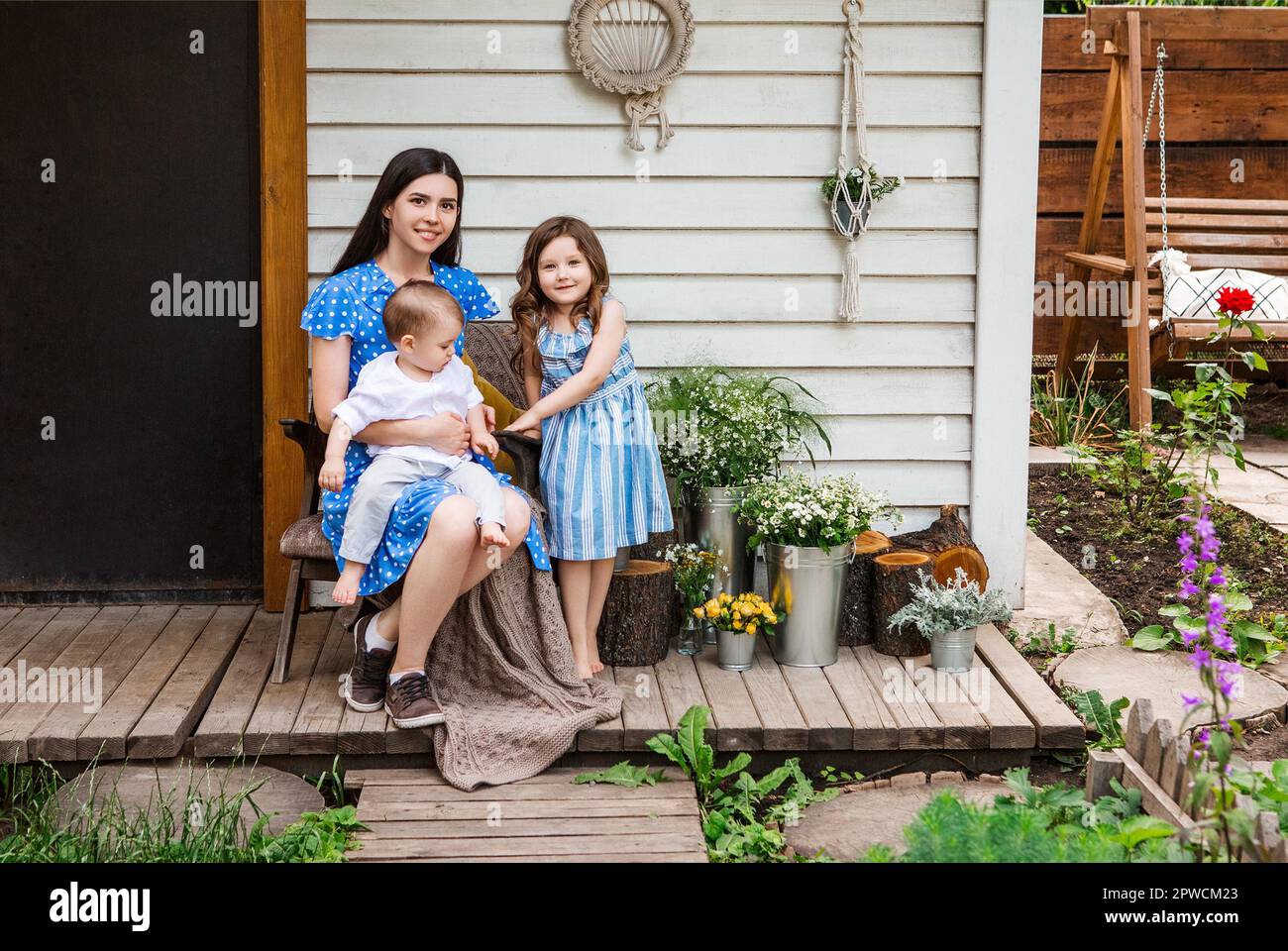Young delighted mother sitting in armchair with adorable little ...