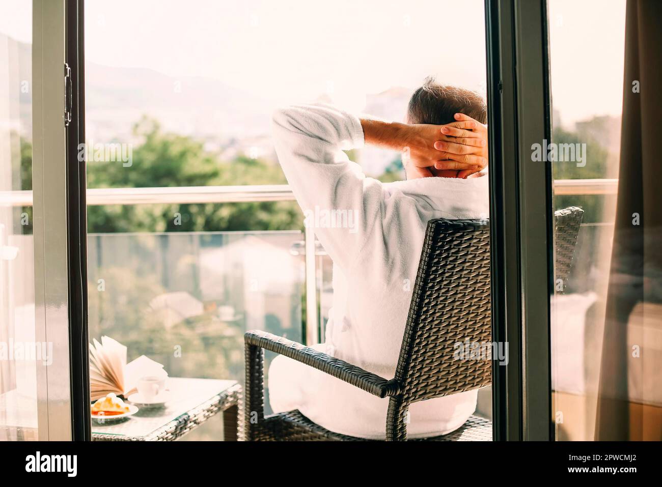Back view of anonymous male holding hands behind head and chilling on ...