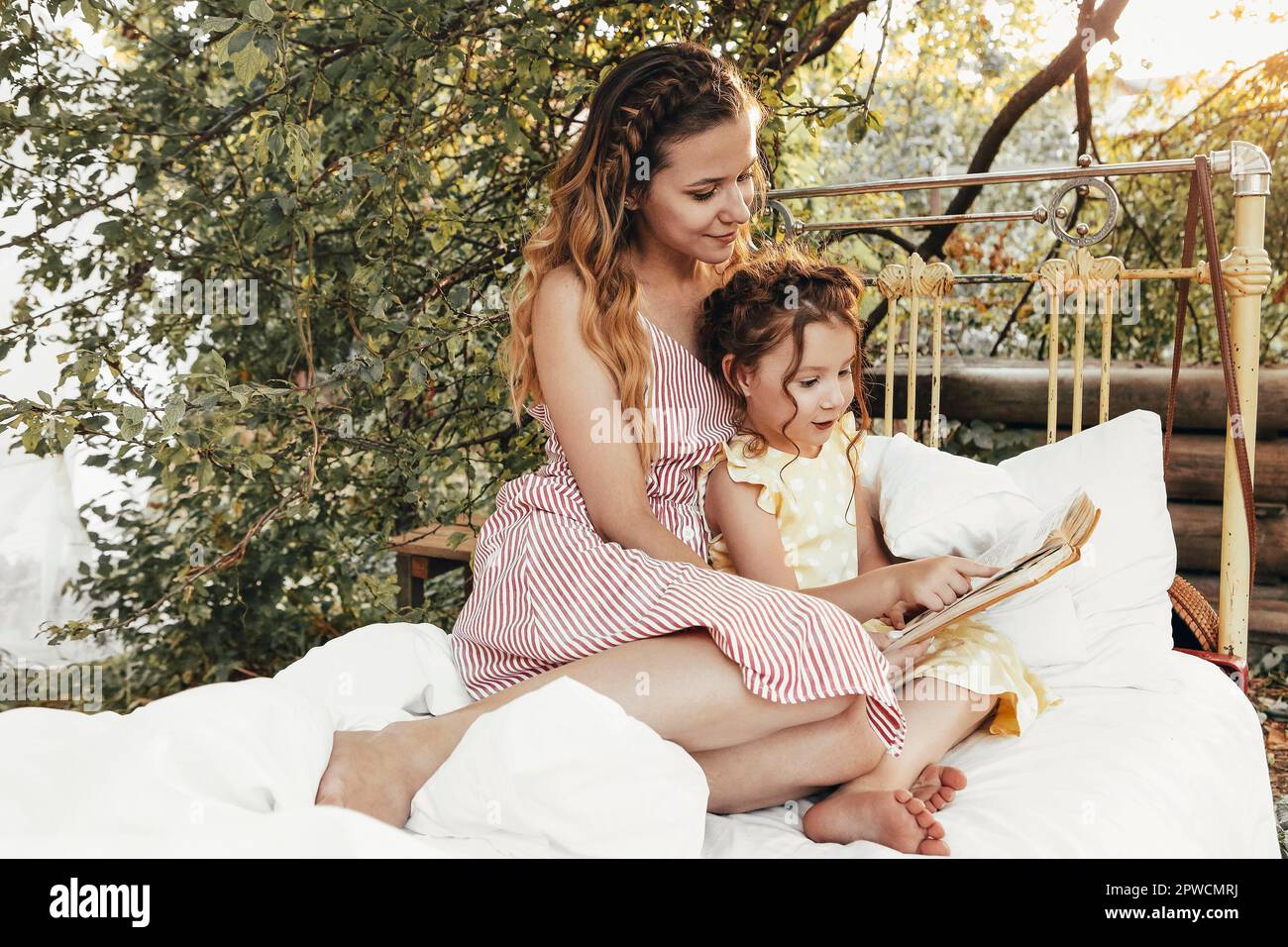 Beautiful mother and child spending time together on sunny terrace near ...
