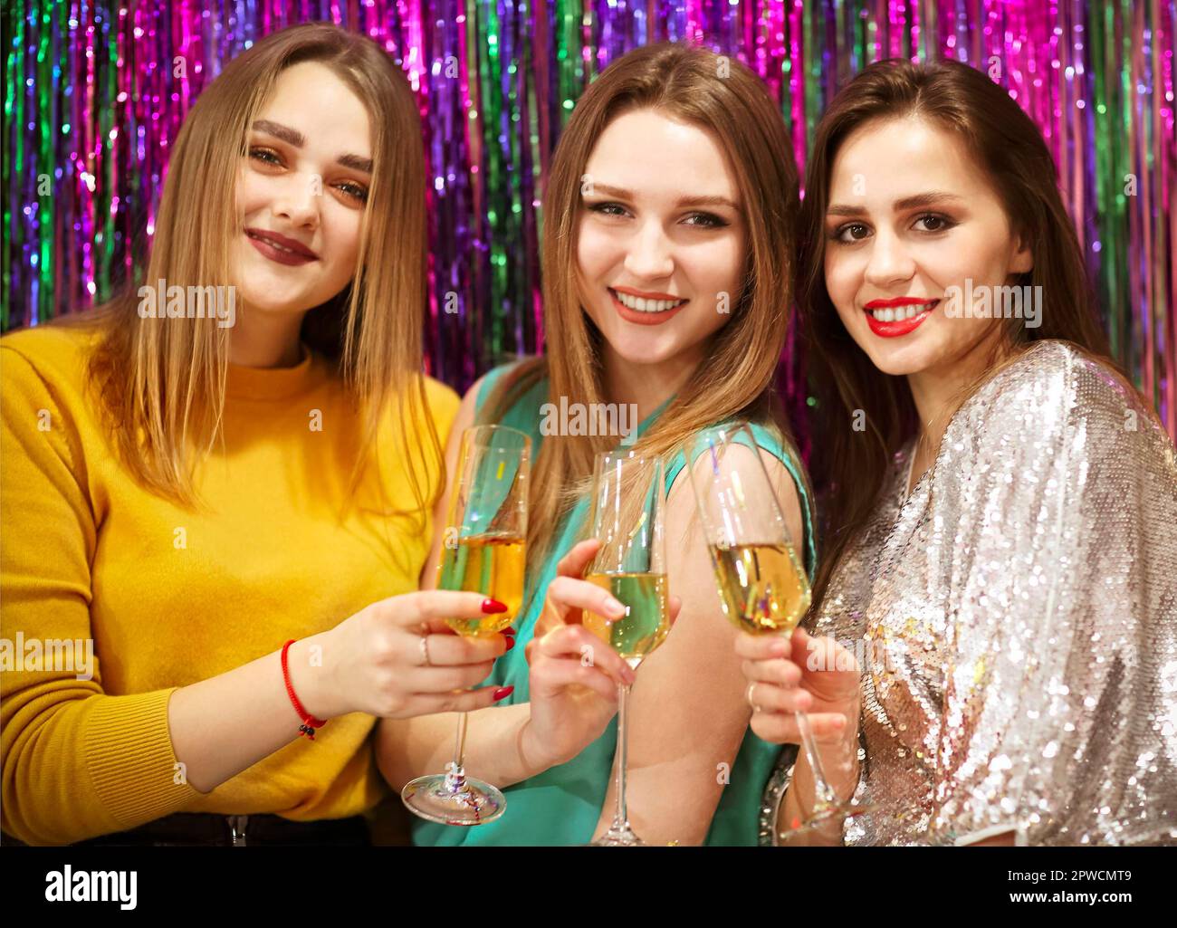 Female friends clinking glasses of wine while having fun during luxury ...