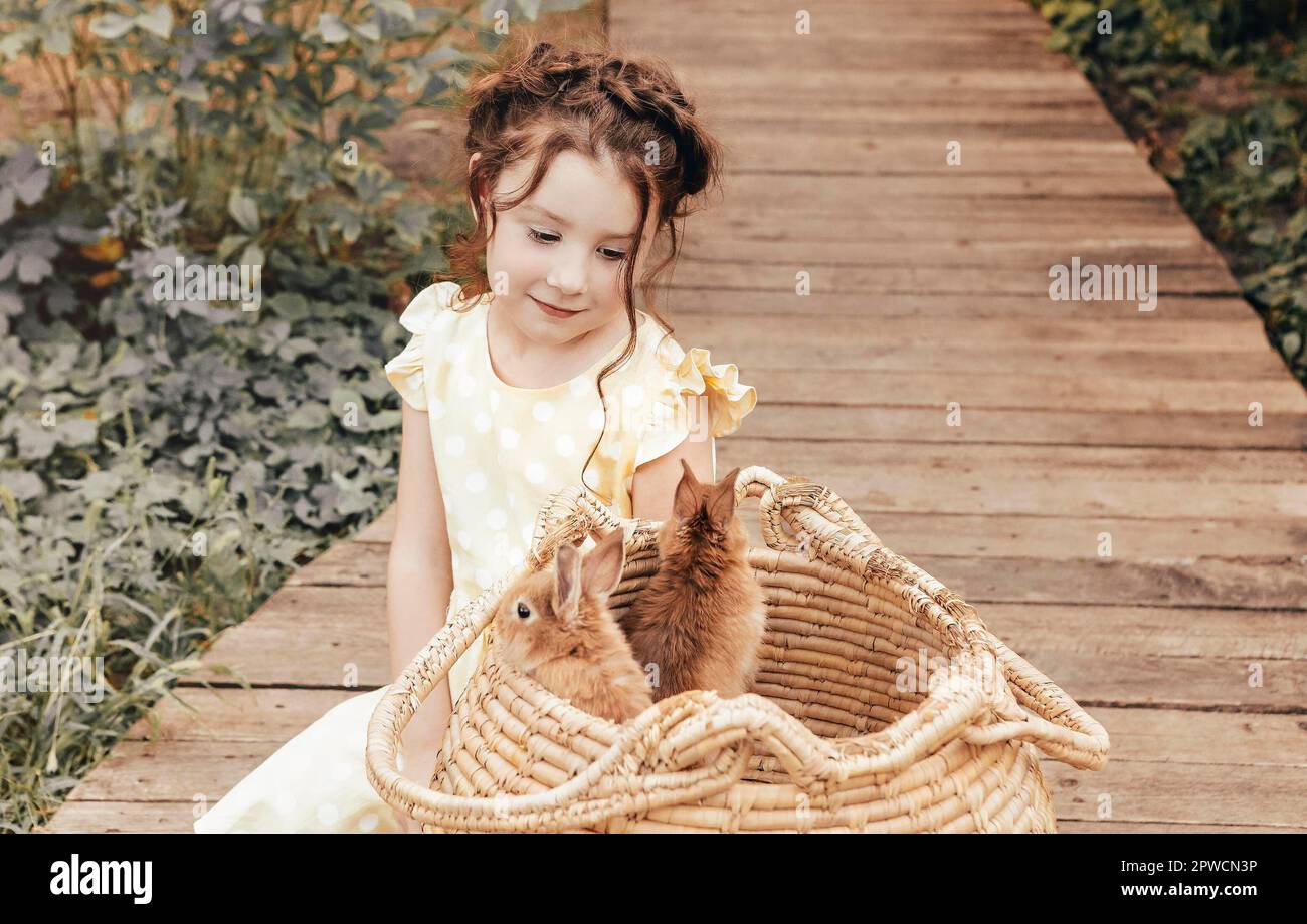 Little pretty girl in summer dress sitting outside on wooden path in ...