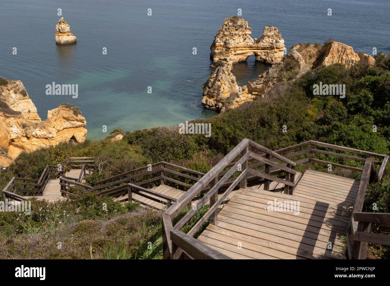 Wooden stairs and rock formation at Praia do Camilo on the coast of ...