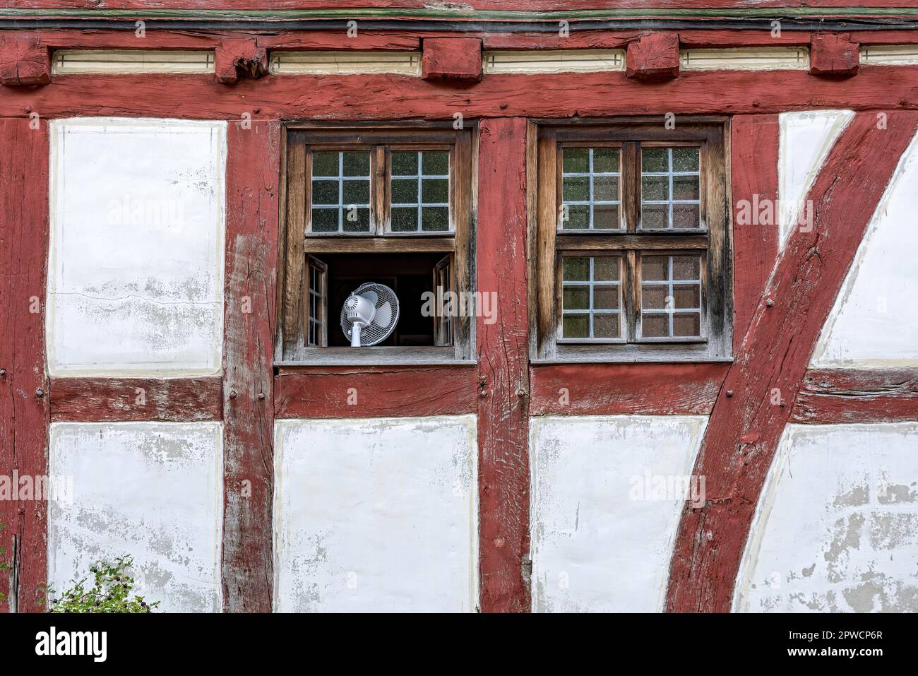 Window with fan for cooling the room, wooden beams, official house from ...