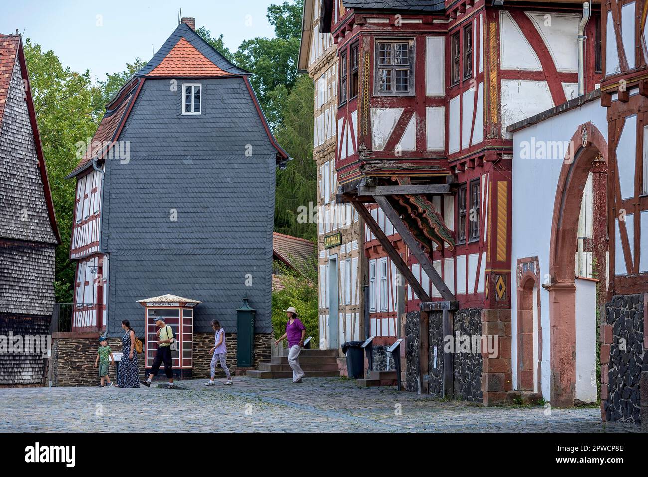People in a street with historic half-timbered houses, in the back ...