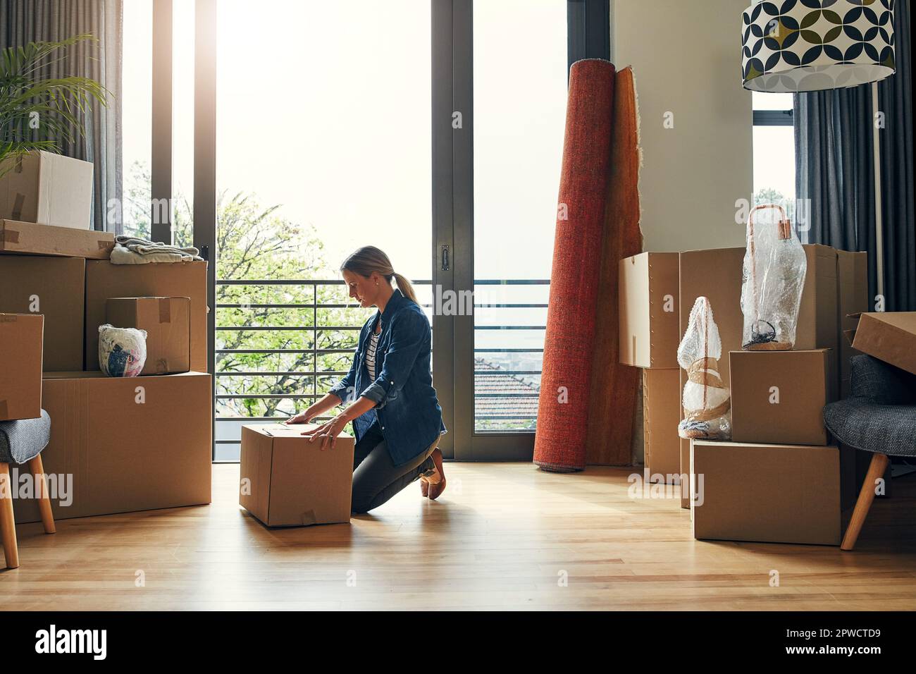 What could be in this box. a focused middle aged woman packing out a ...