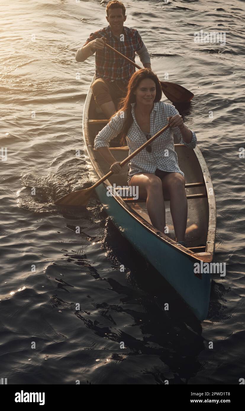 Having fun on our lake journey. a young couple rowing a boat out on the ...