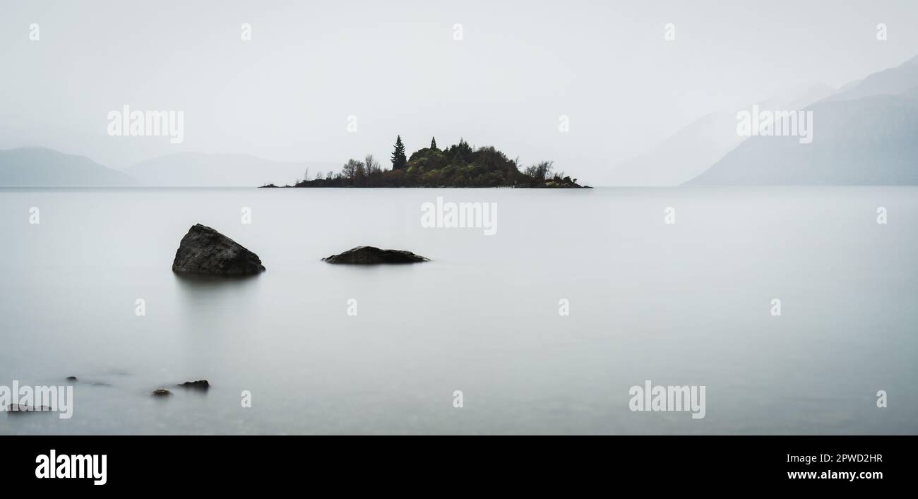 Ruby Island on Lake Wanaka with background mountains in the mist, Otago ...