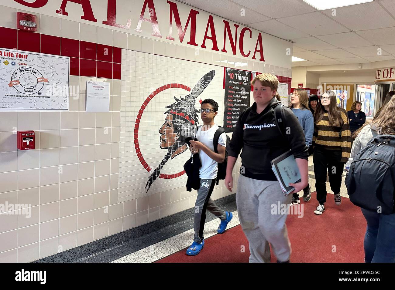 Students walk past a logo that is tiled into the wall at Salamanca High ...